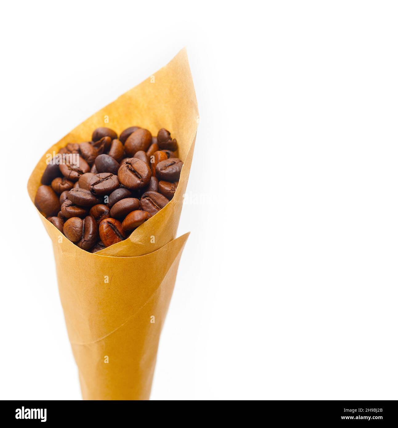 espresso coffee beans on a paper cone cornucopia over white background ...