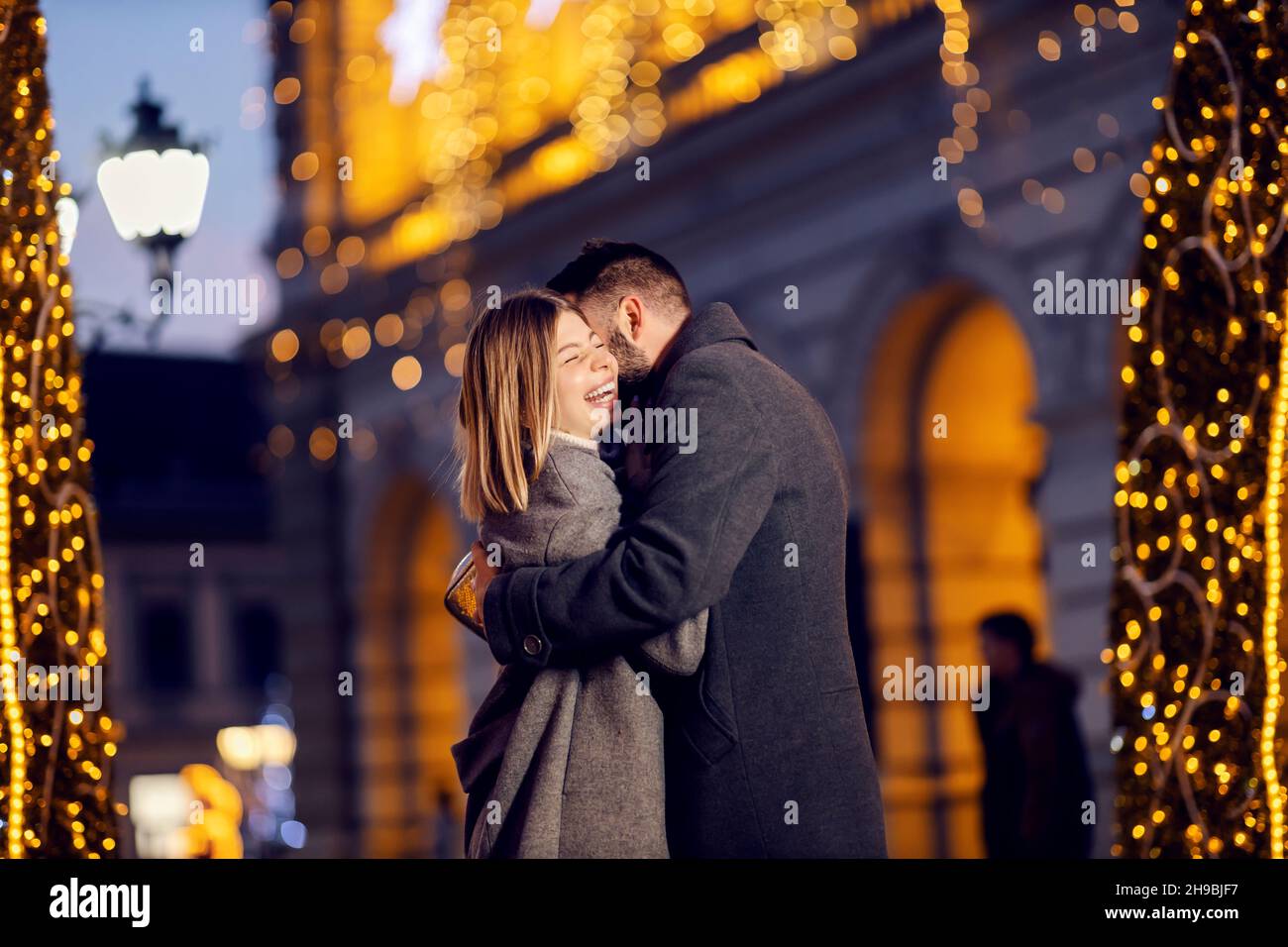 Christmas people hugging on the street on New Year. A happy couple in ...