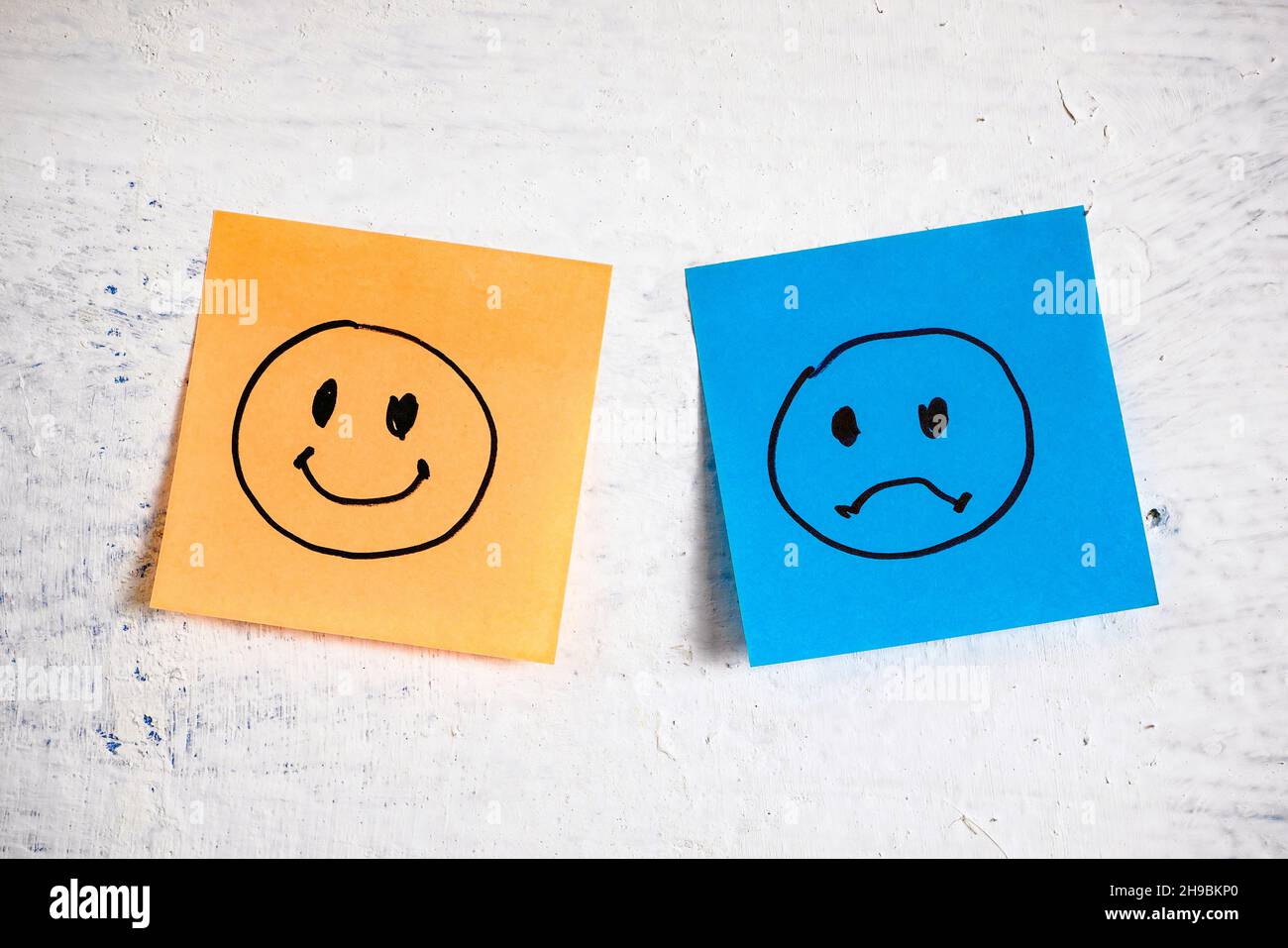 Happy and sad faces hand drawn on sticky notes on painted wall Stock ...