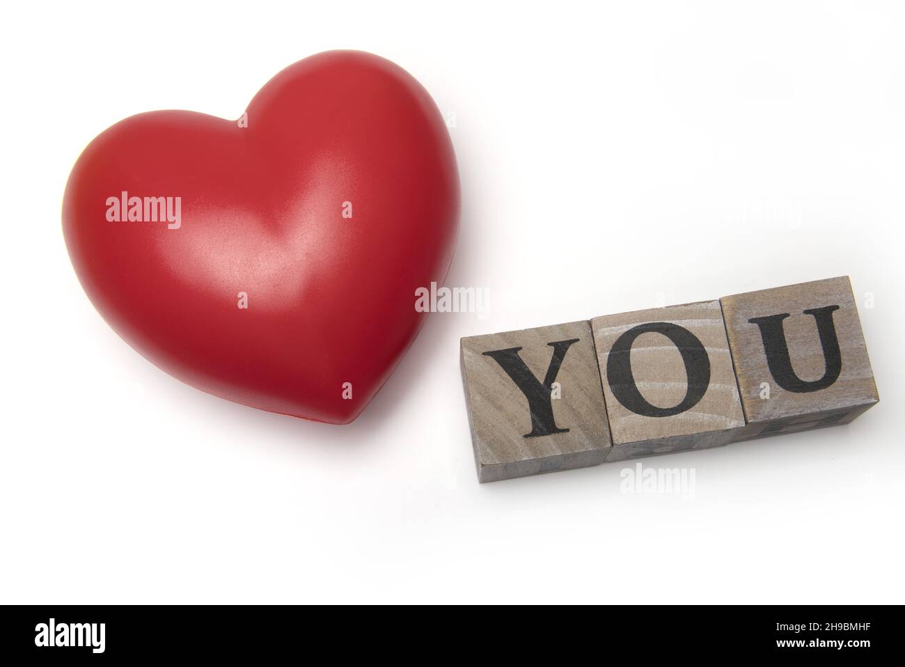a big red heart next to wooden letter cube showing love isolated on ...