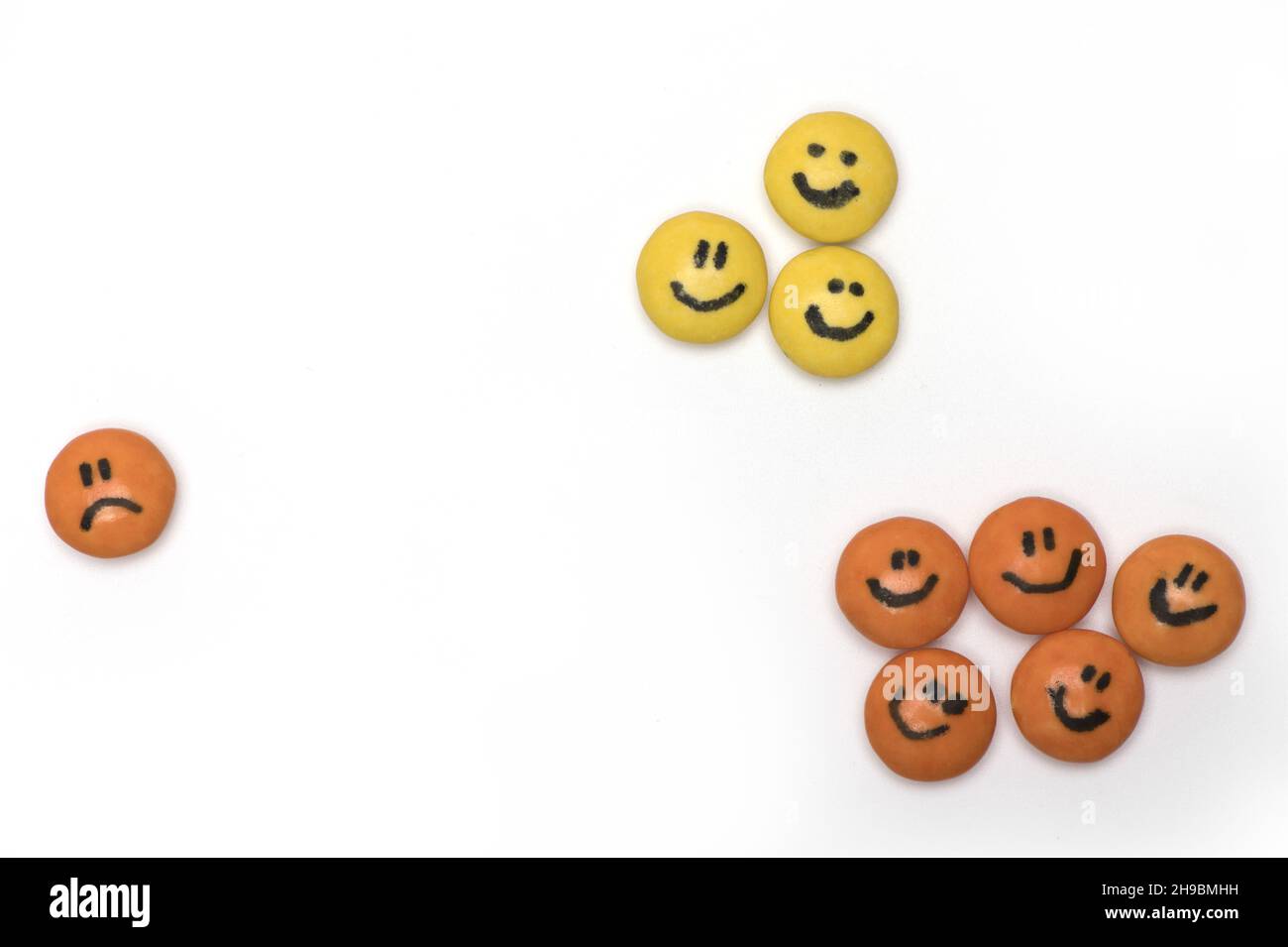 two groups of round candy with faces on them representing happiness and ...