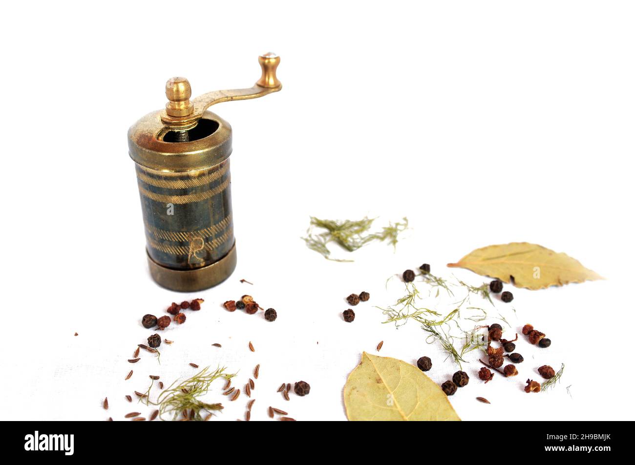 brass mill or grinder and some spices Stock Photo - Alamy