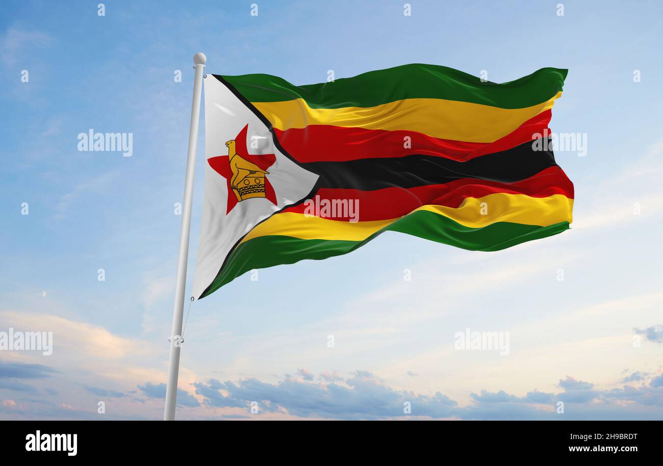 official flag of Saint Helena at cloudy sky background on sunset ...