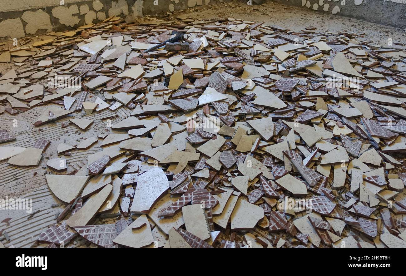 A kitchen floor covered with broken floor tiles Stock Photo - Alamy