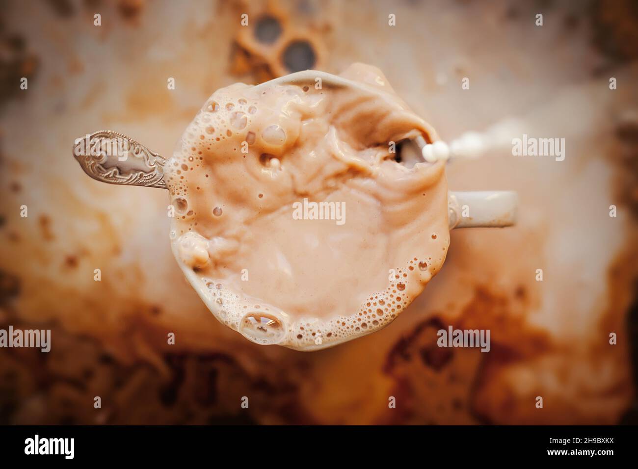 The human was pouring milk into a coffee mug. Mess in the kitchen. A ...