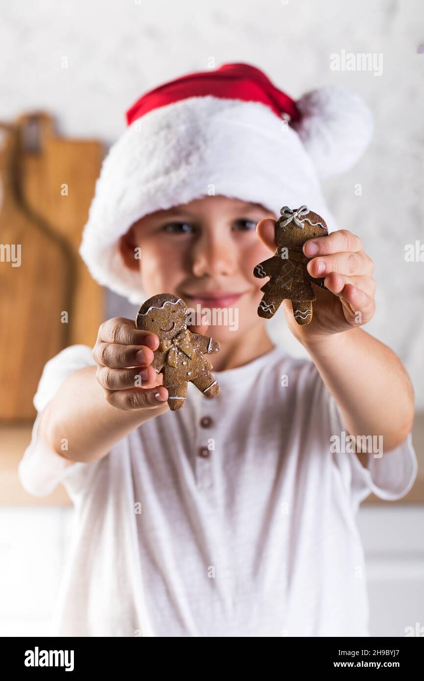 Smiling little child shows funny gingerbread men prepared for Christmas ...