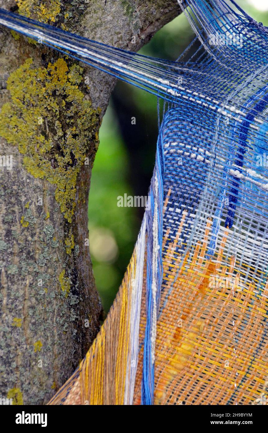 woven fabric hanging from tree trunk Stock Photo - Alamy