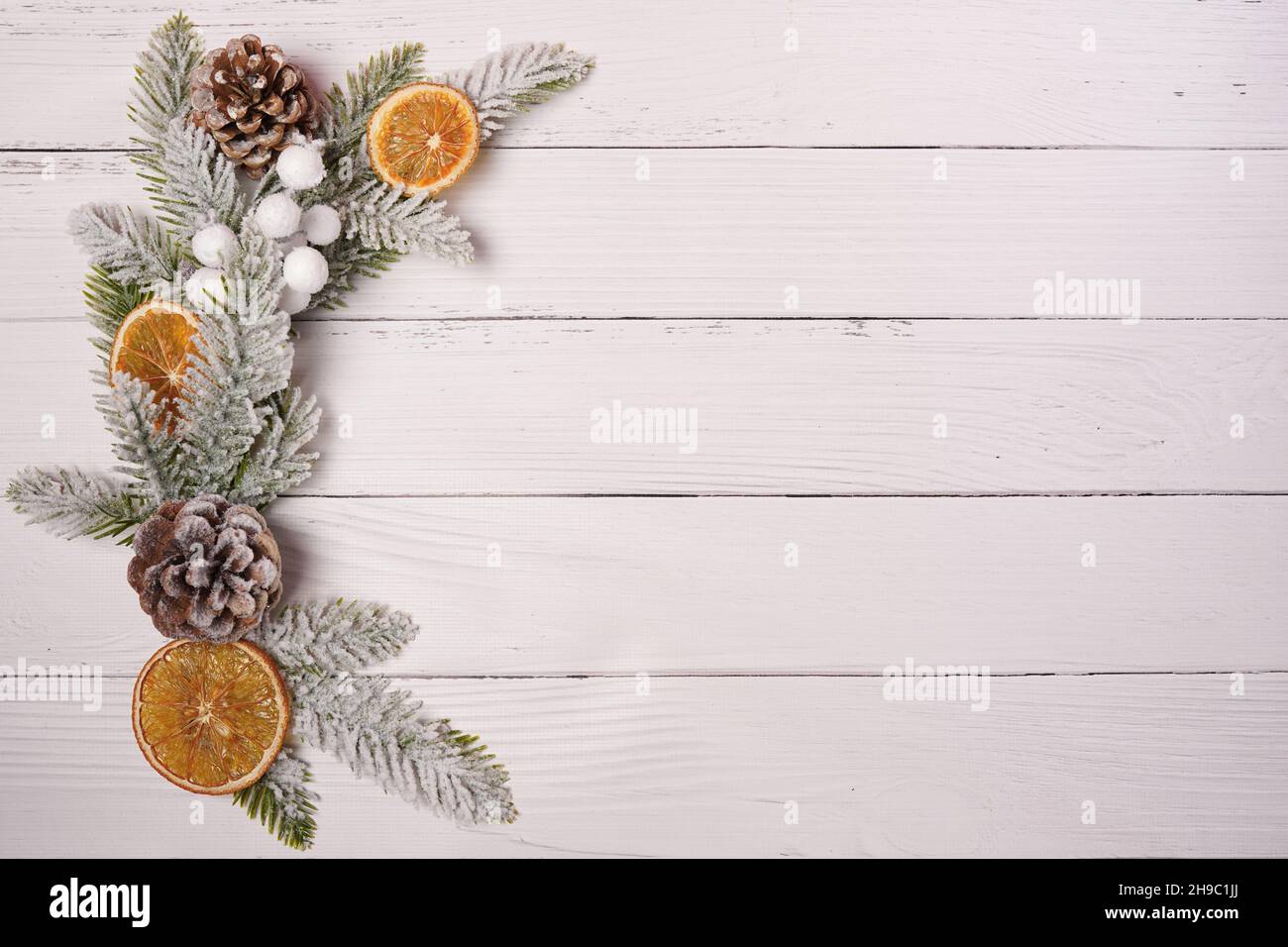 White shabby Christmas border with snow covered fir tree branch, wooden ...
