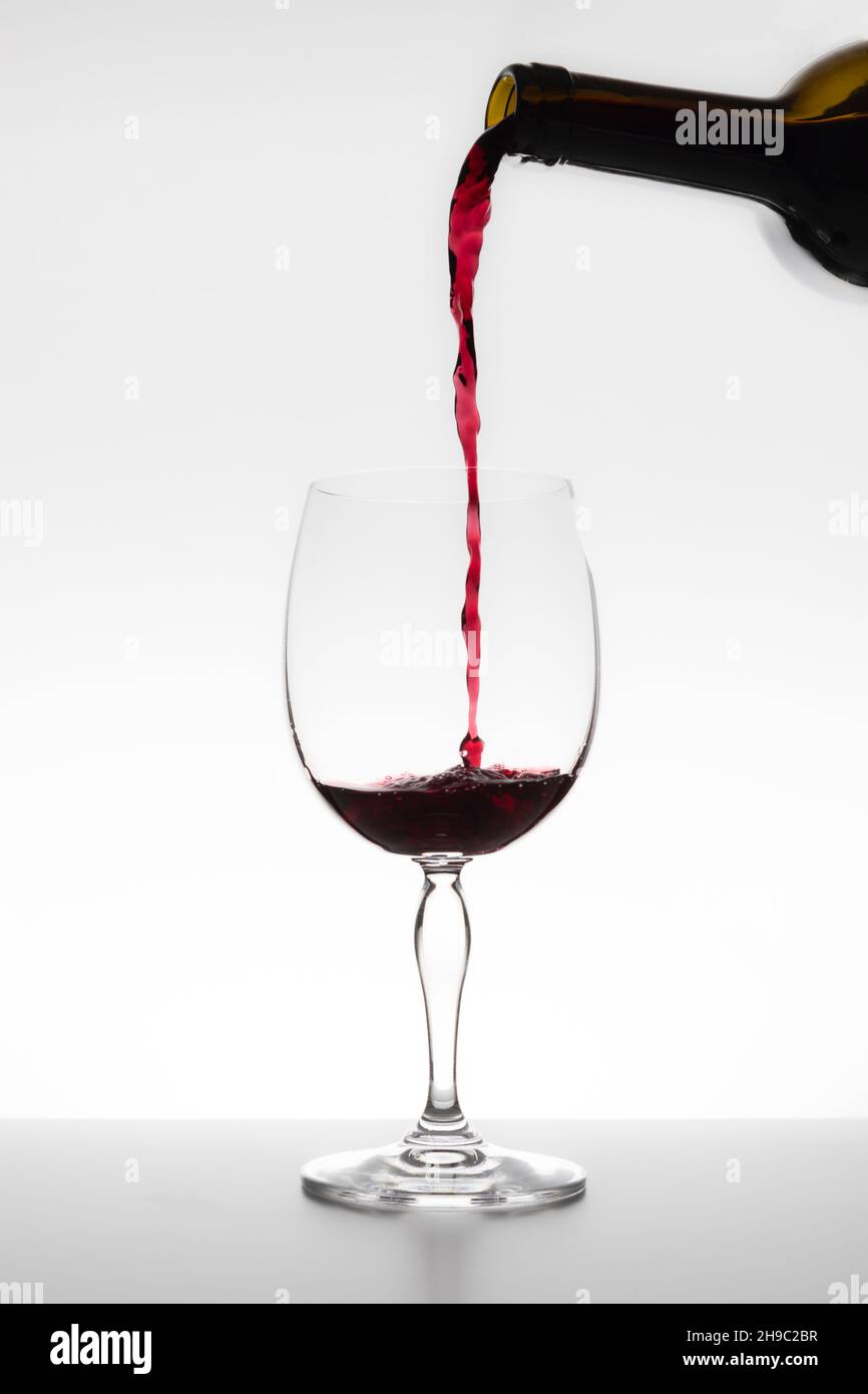 Red wine falling in glass on white background Stock Photo - Alamy