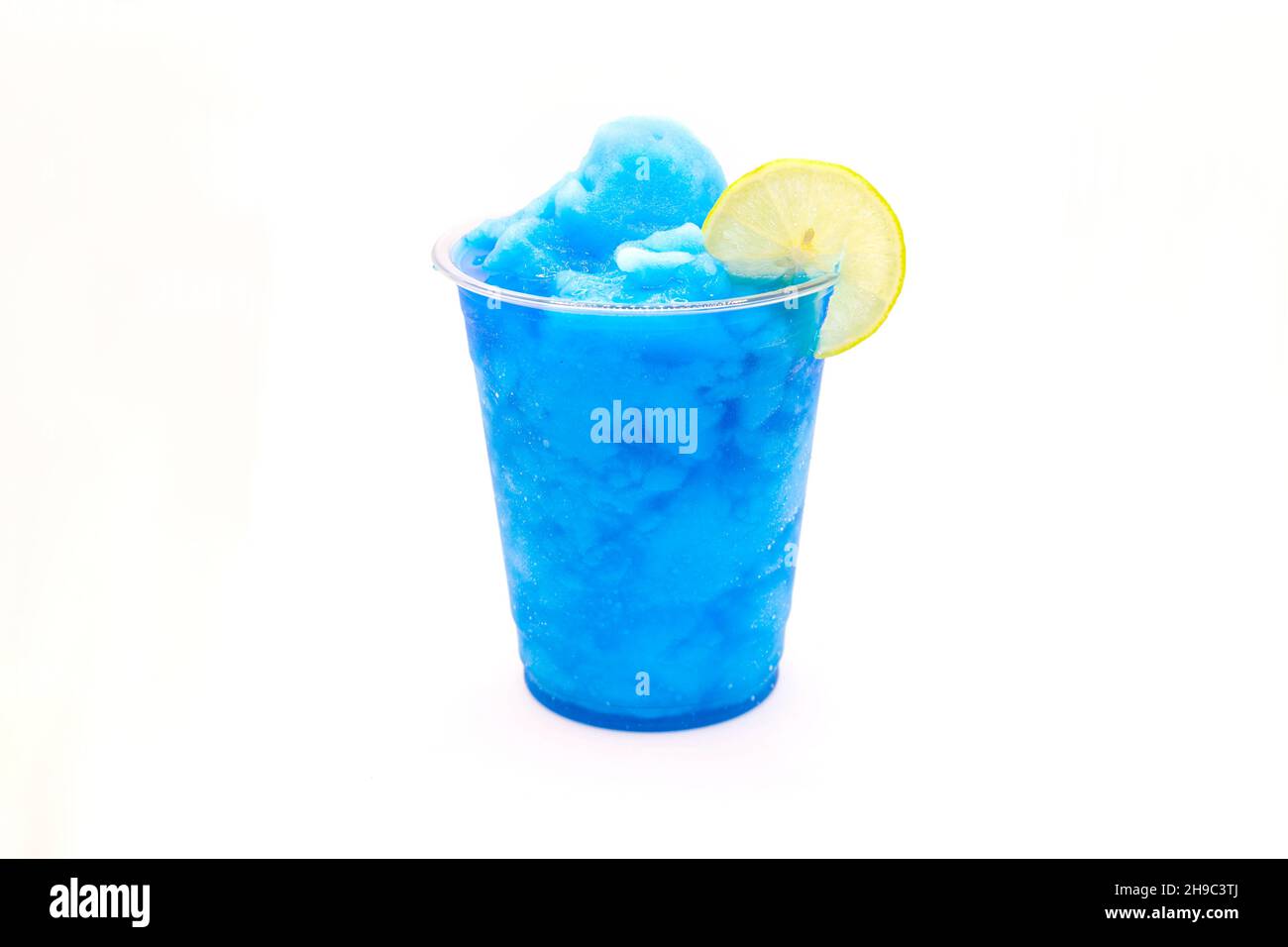 Electric blue lagoon slush lemonade with a slice of lemon in a ...