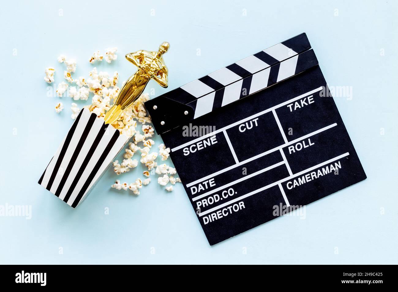 Golden film award statue with clapper board and popcorn Stock Photo - Alamy