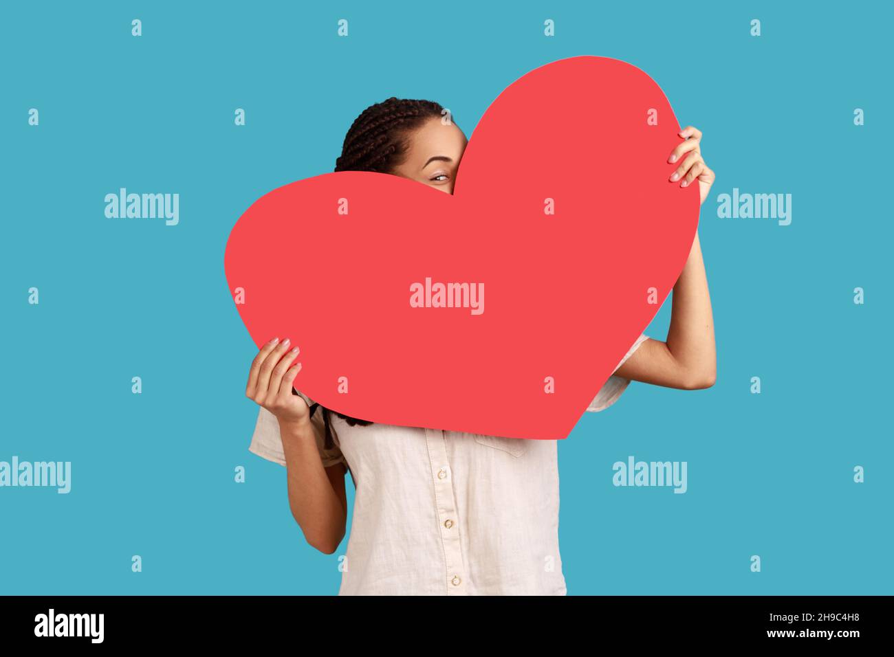 Portrait of unknown woman holding big red heart in hands, peeping from ...