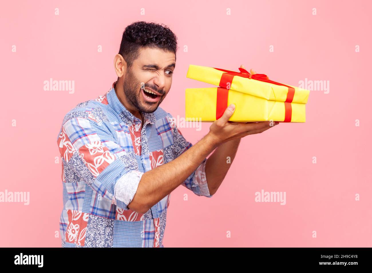 Portrait of curious happy man opening gift, peeking inside box with ...