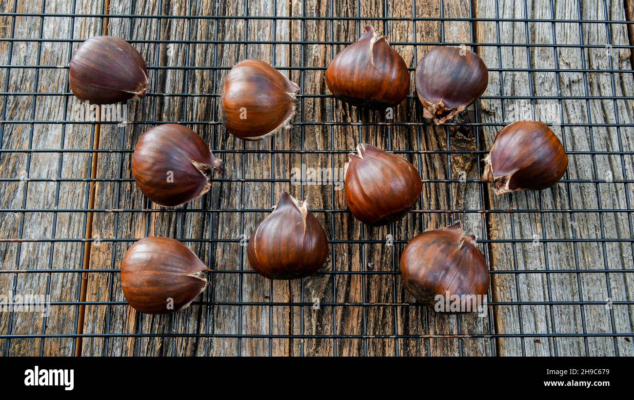 Chestnuts on cooling screen on rustic table top Stock Photo - Alamy