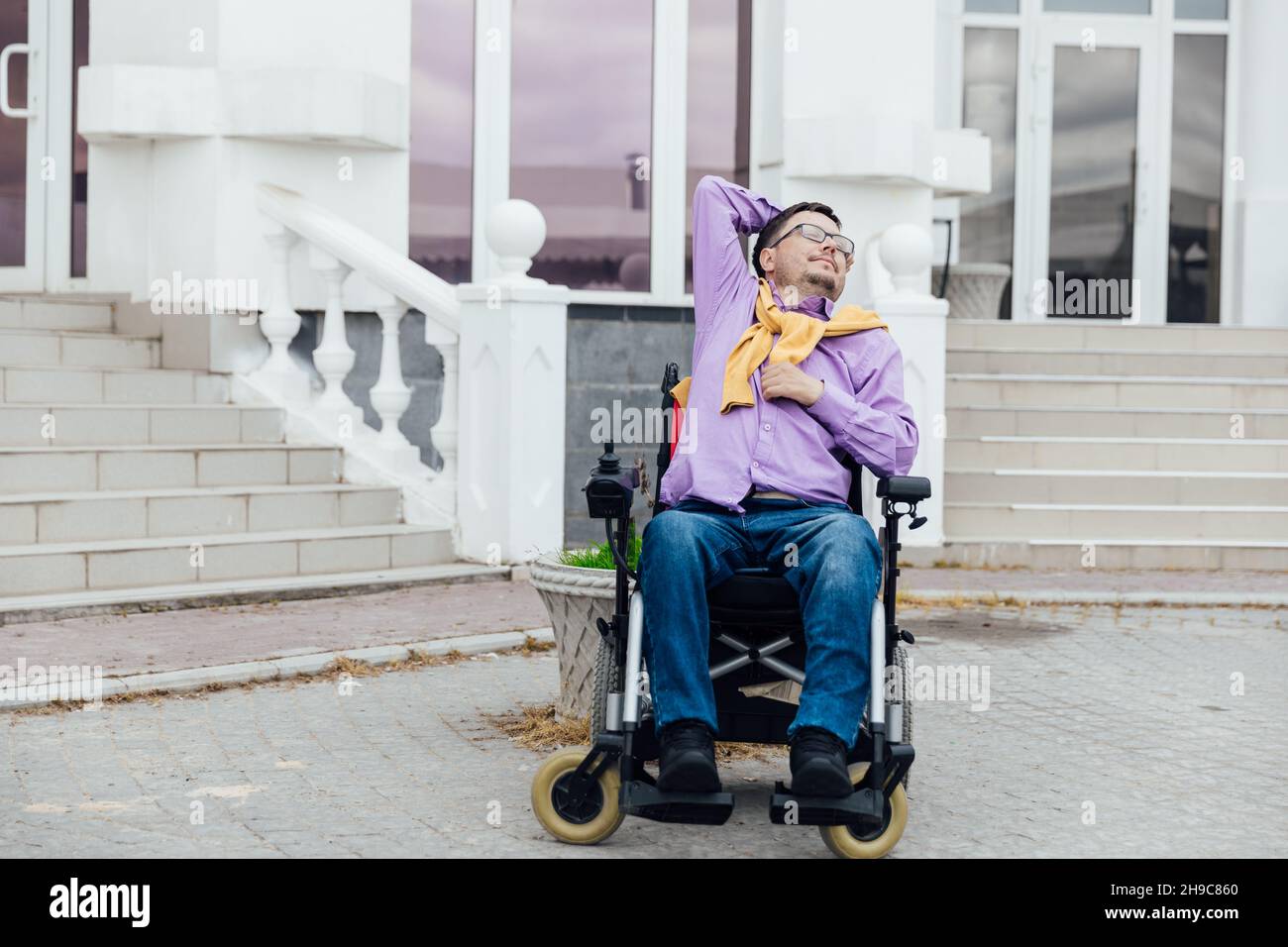 a man with a disability in a wheelchair on a walk on the street Stock ...