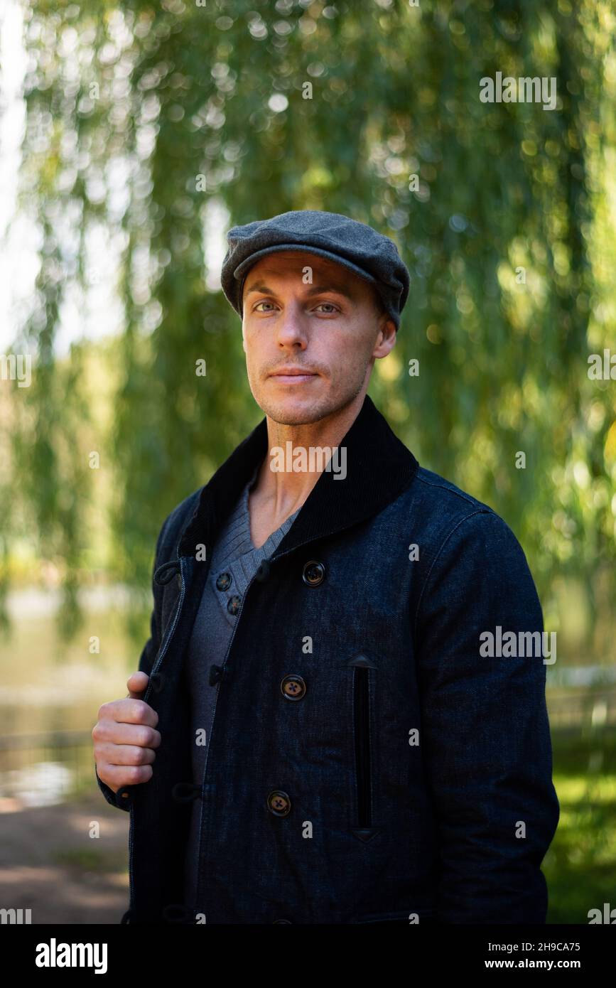 A man in a coat and cap walks around the city Stock Photo - Alamy