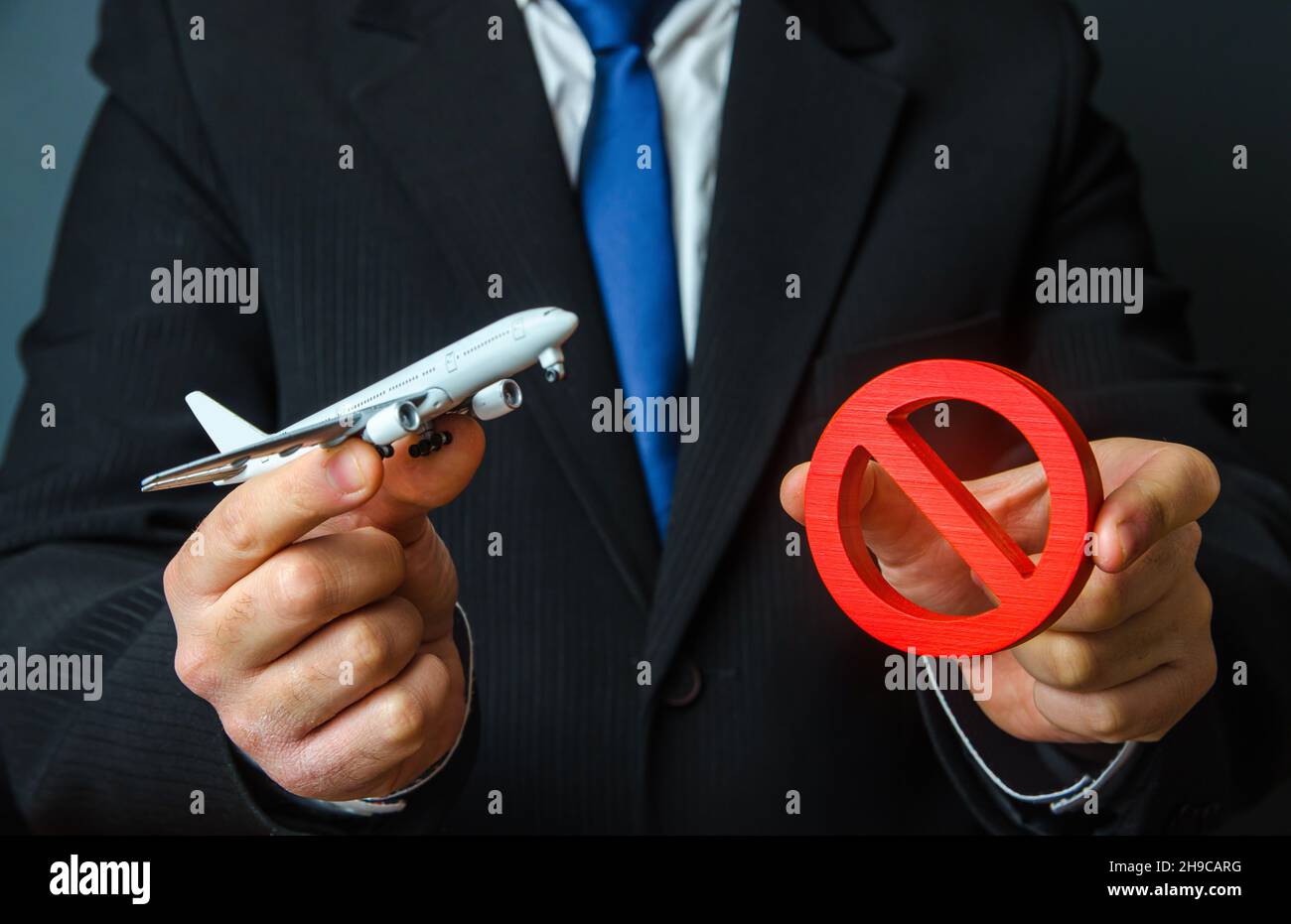 Man is holding an airplane and a red NO sign. Ban on flights. Non ...