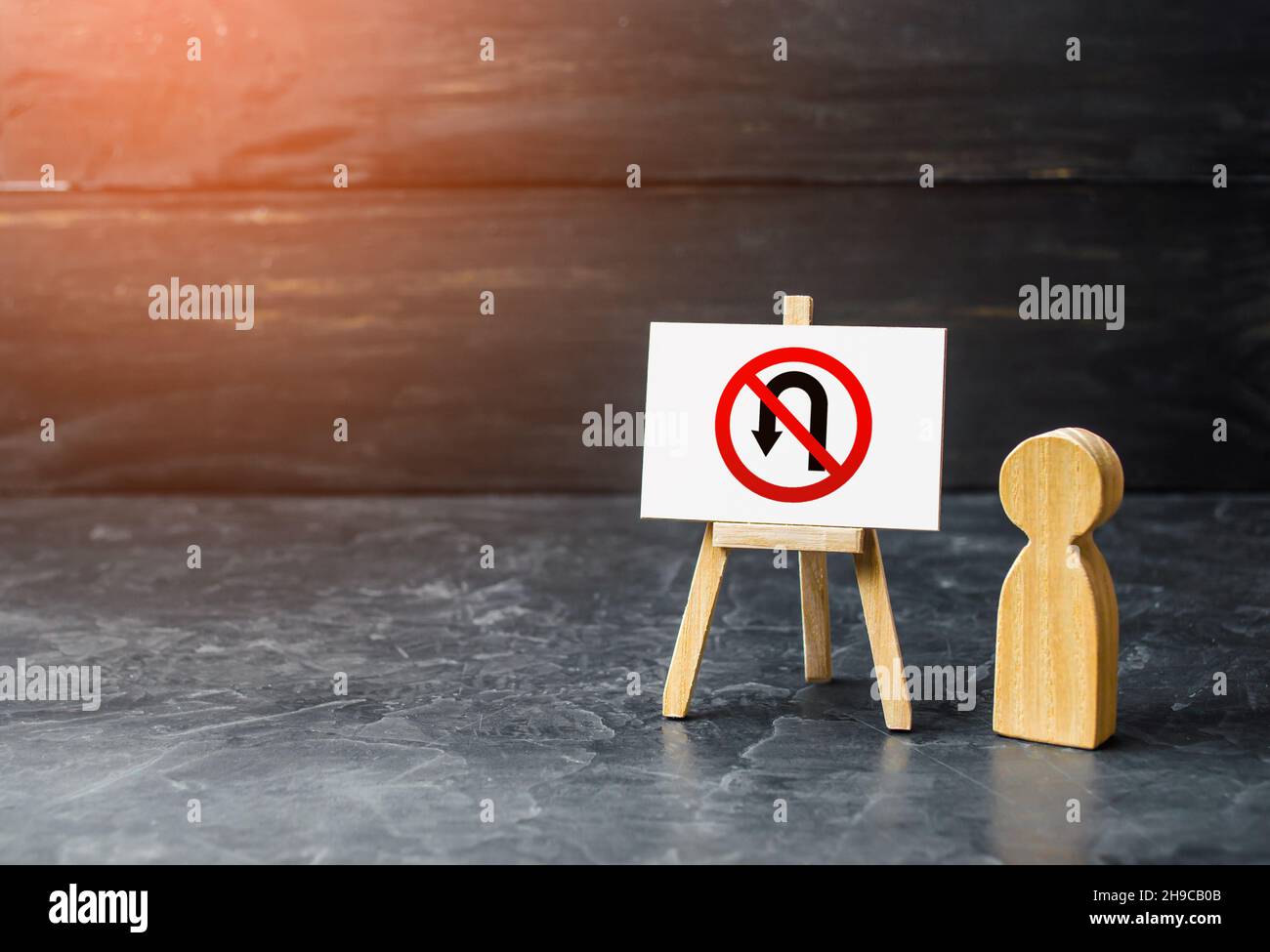 Men near no turning back traffic sign easel. Turn arrow and red ...