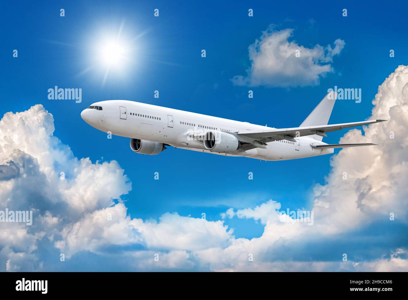 White wide body passenger airplane flies in the air above scenic clouds ...