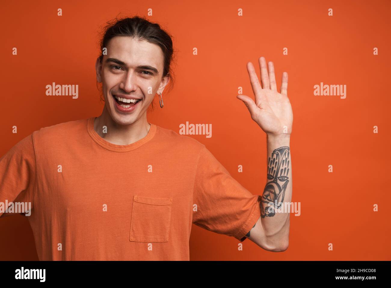 Portrait of a happy oung white casual man with long brown hair standing ...