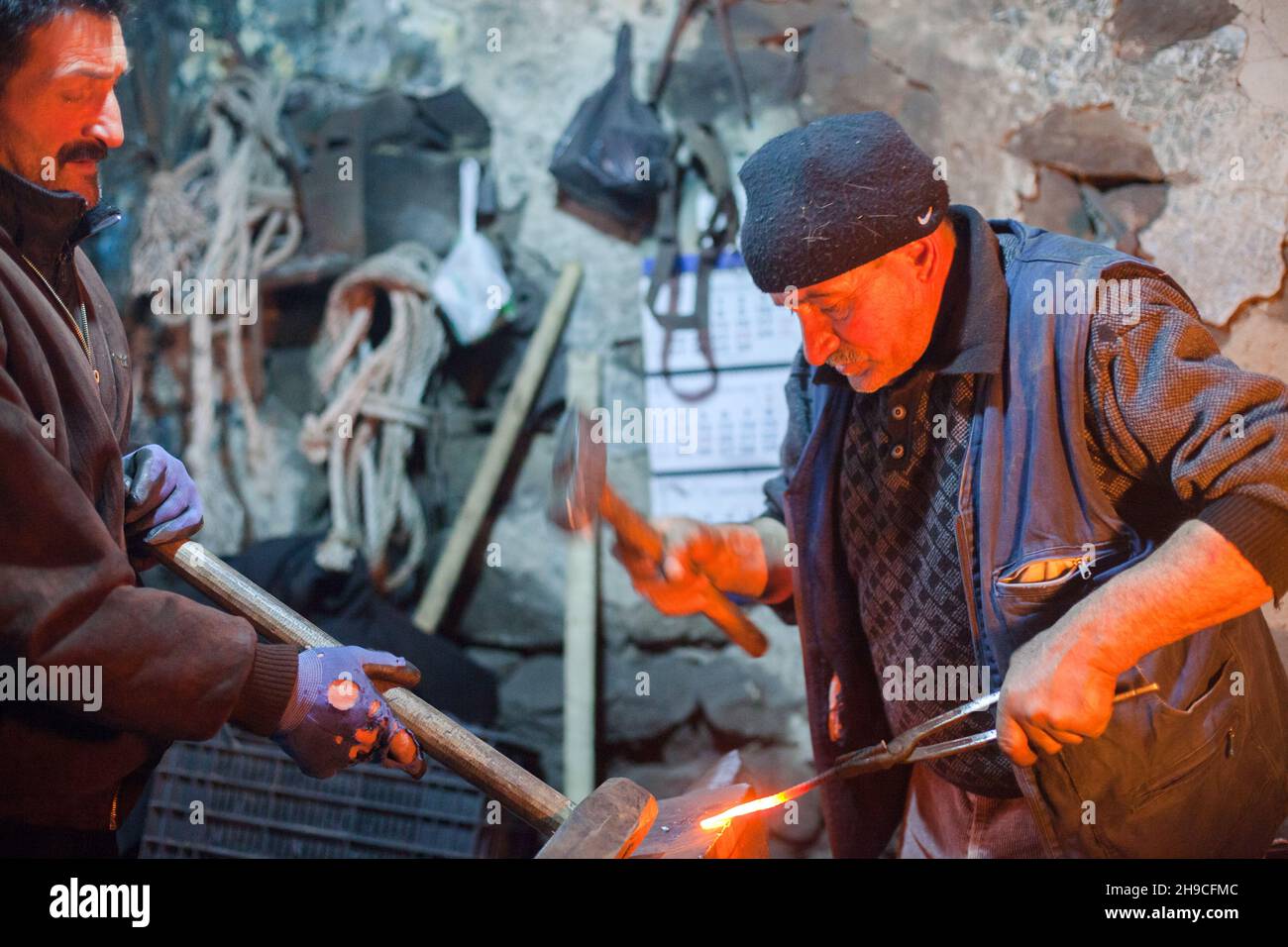Kars,Turkey - 01-23-2016:Two old blacksmith working metal with hammer ...