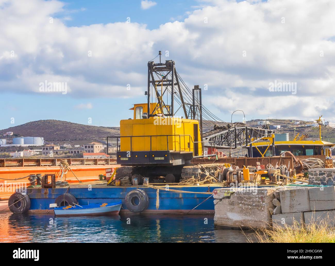 Yellow Excavator On Barge In Shipyard. Sky-Clouds in the background ...