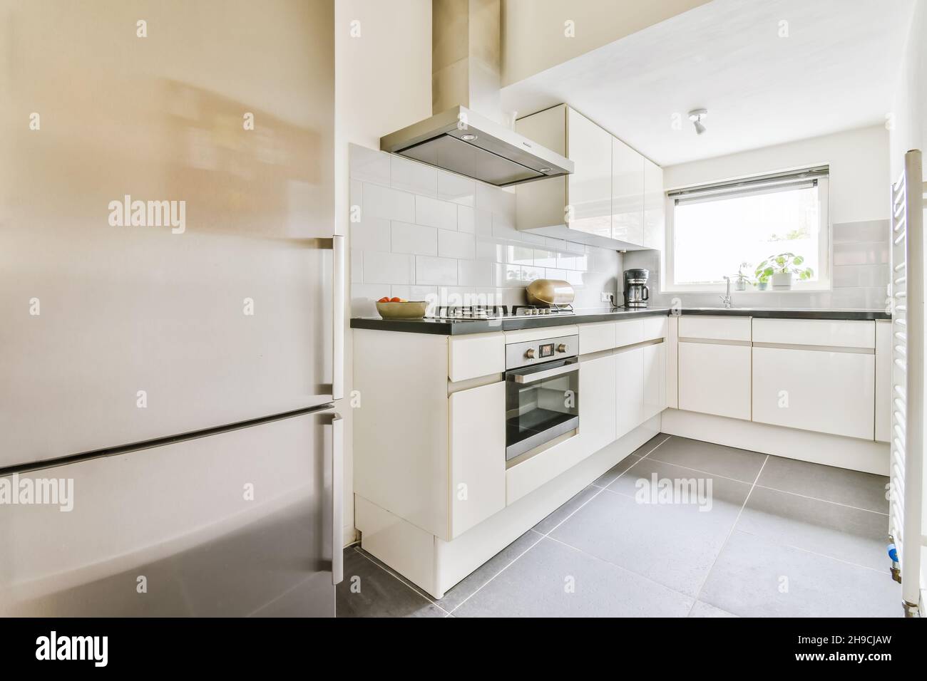 Adorable kitchen area with modern oven and refrigerator Stock Photo - Alamy