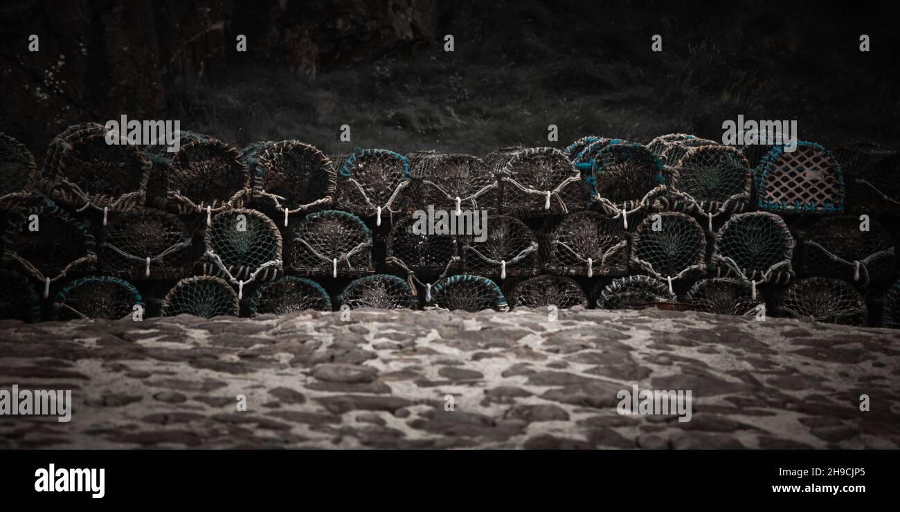 Fishing pots stacked on the quayside Stock Photo - Alamy