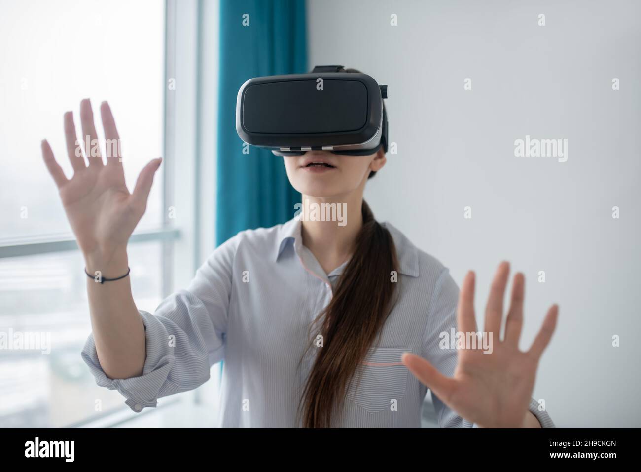 Female gamer in VR glasses standing in a room Stock Photo - Alamy