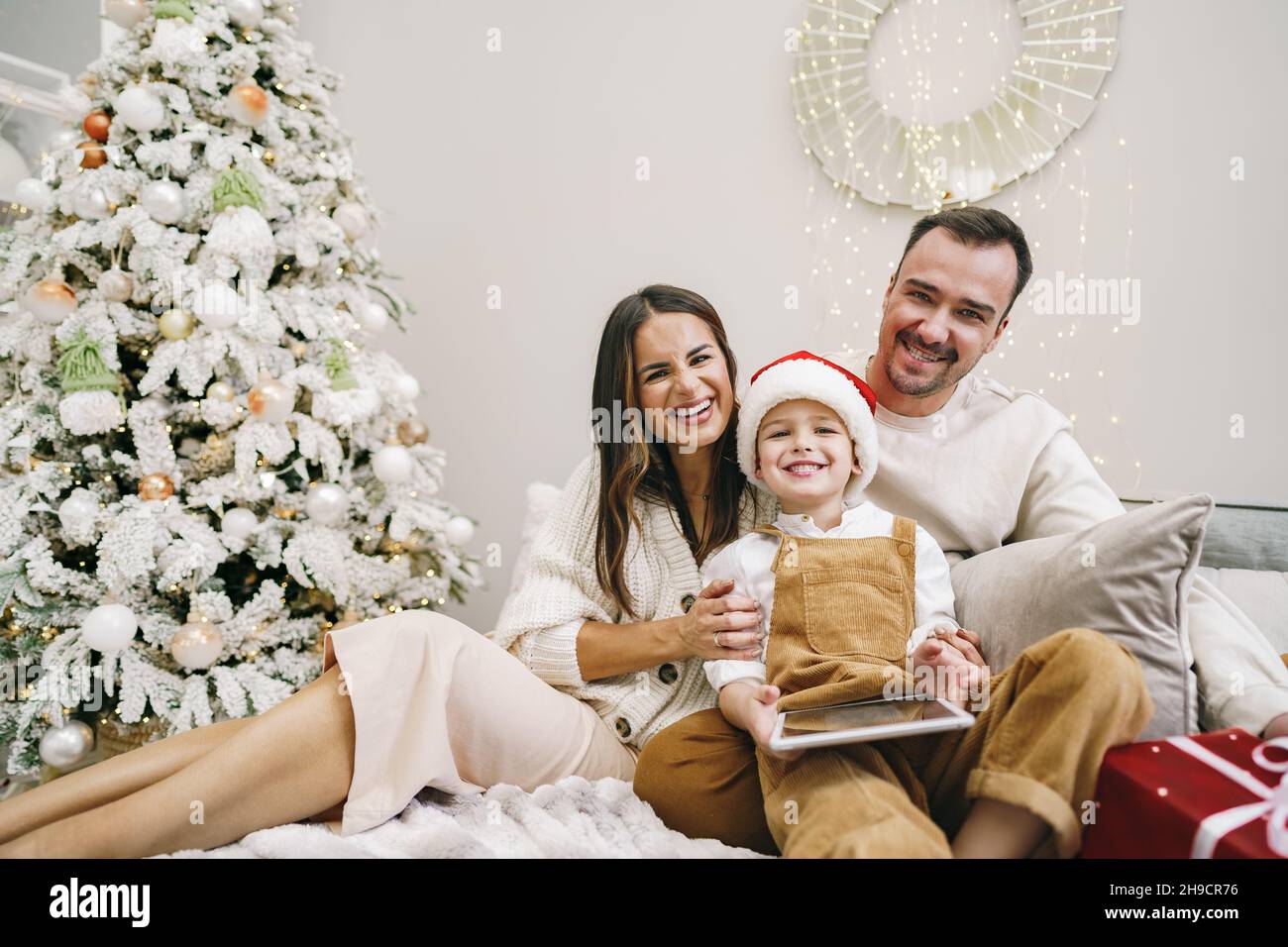 Happy family having fun on digital tablet in bed on Christmas Stock ...
