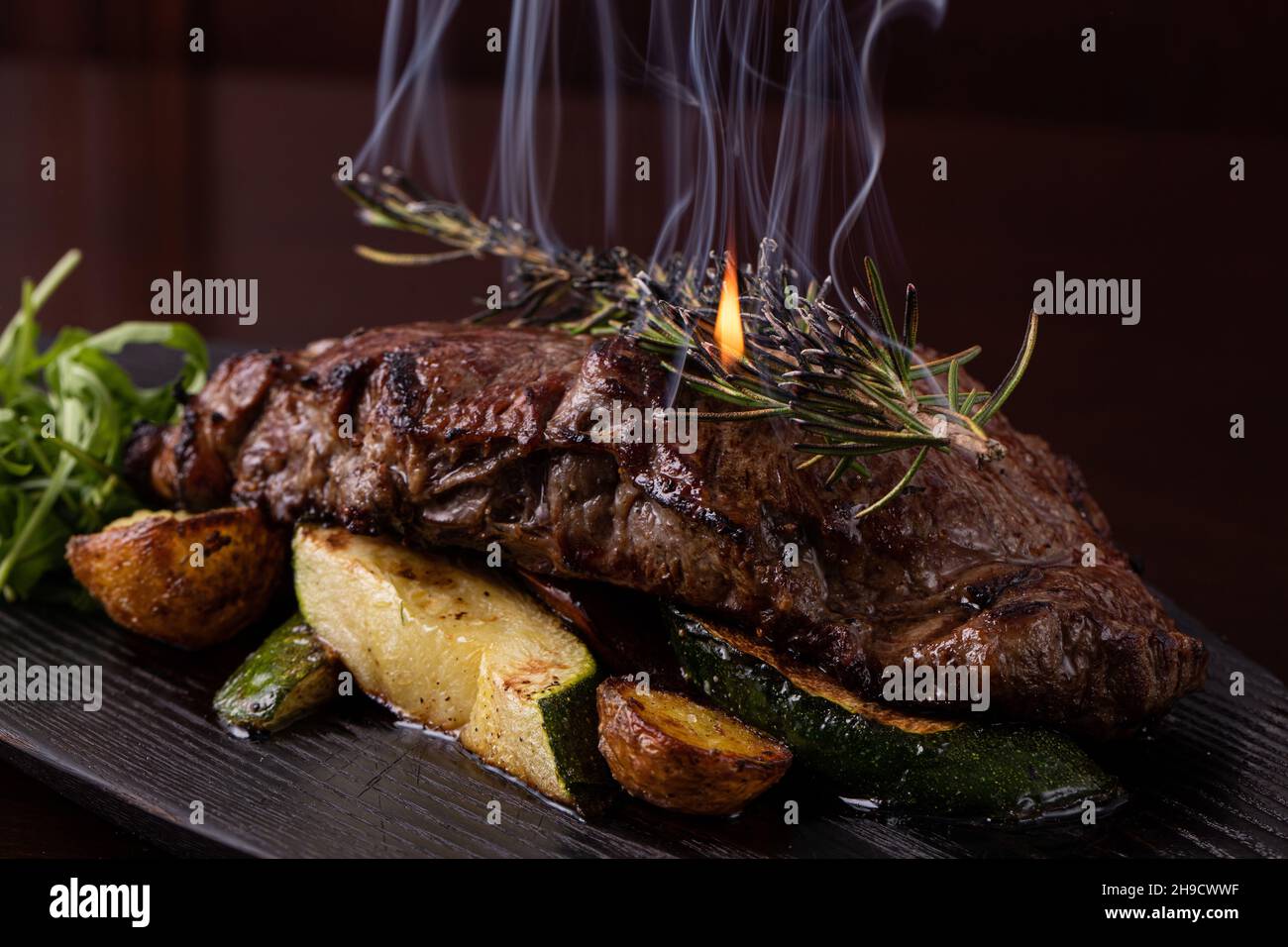 Grilled striploin steak on black dish. steak with fried potatoes and ...