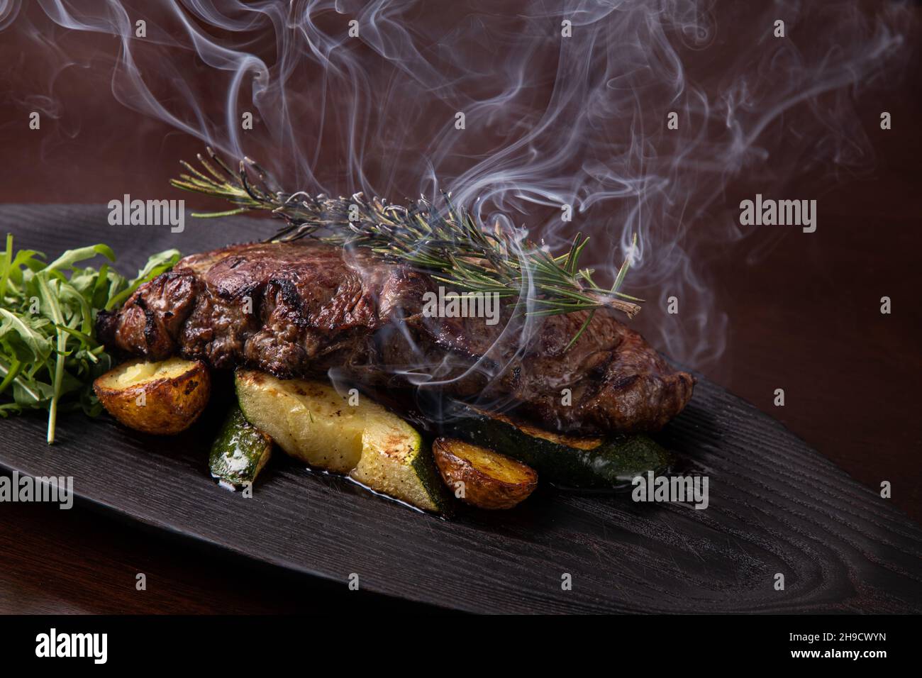 Grilled striploin steak on black dish. steak with fried potatoes and ...