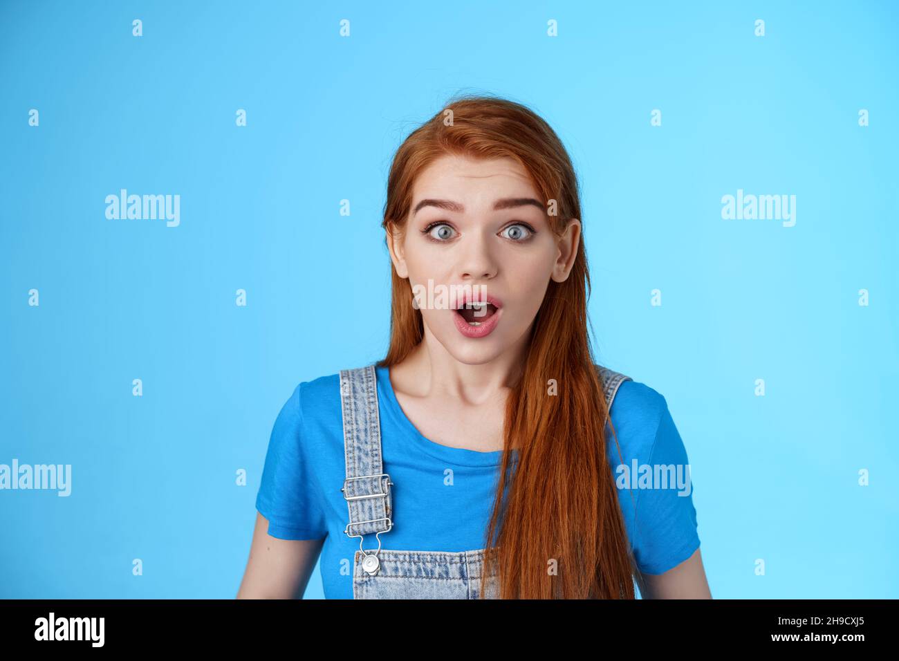 Shocked redhead girl react omg shook, drop jaw speechless, stare ...