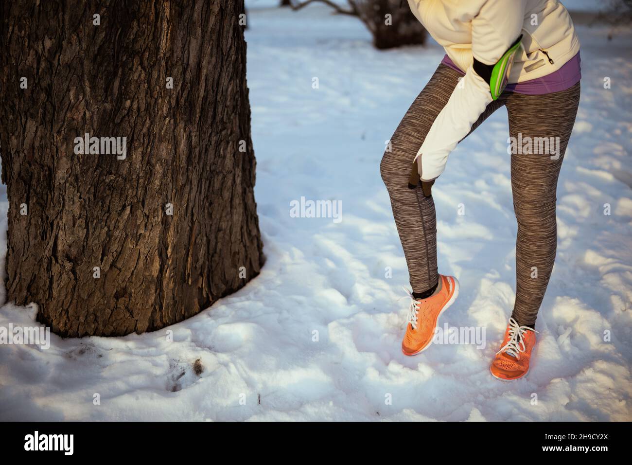 Closeup on woman in white jacket got a leg injury outdoors in the city ...