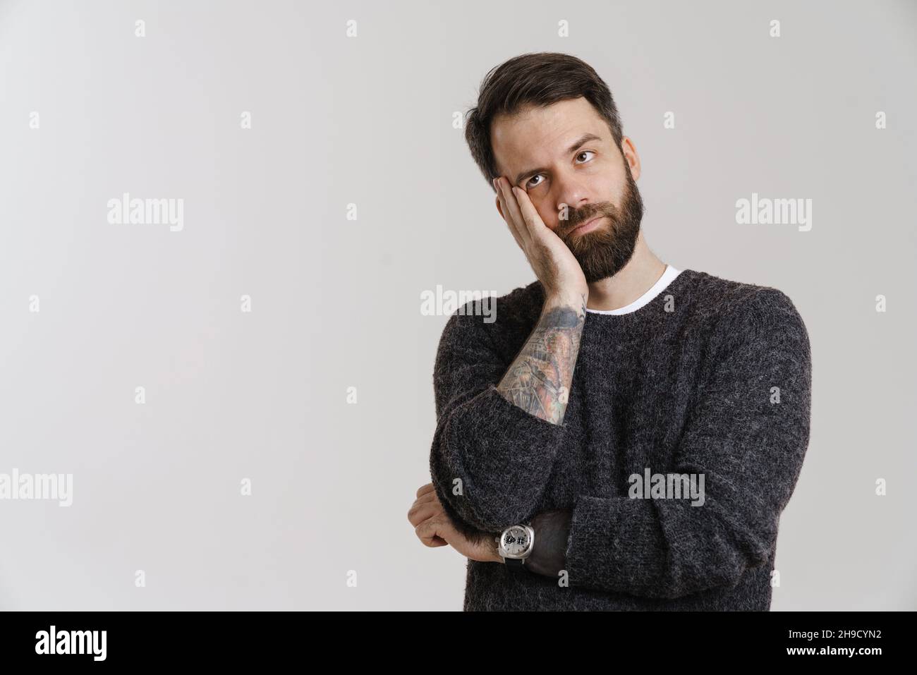 White mid man with beard covering his face and looking at camera ...