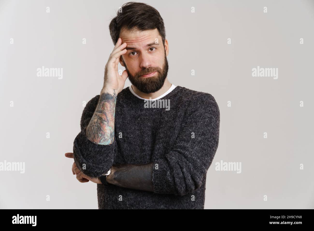 White mid man with beard covering his face and looking at camera ...