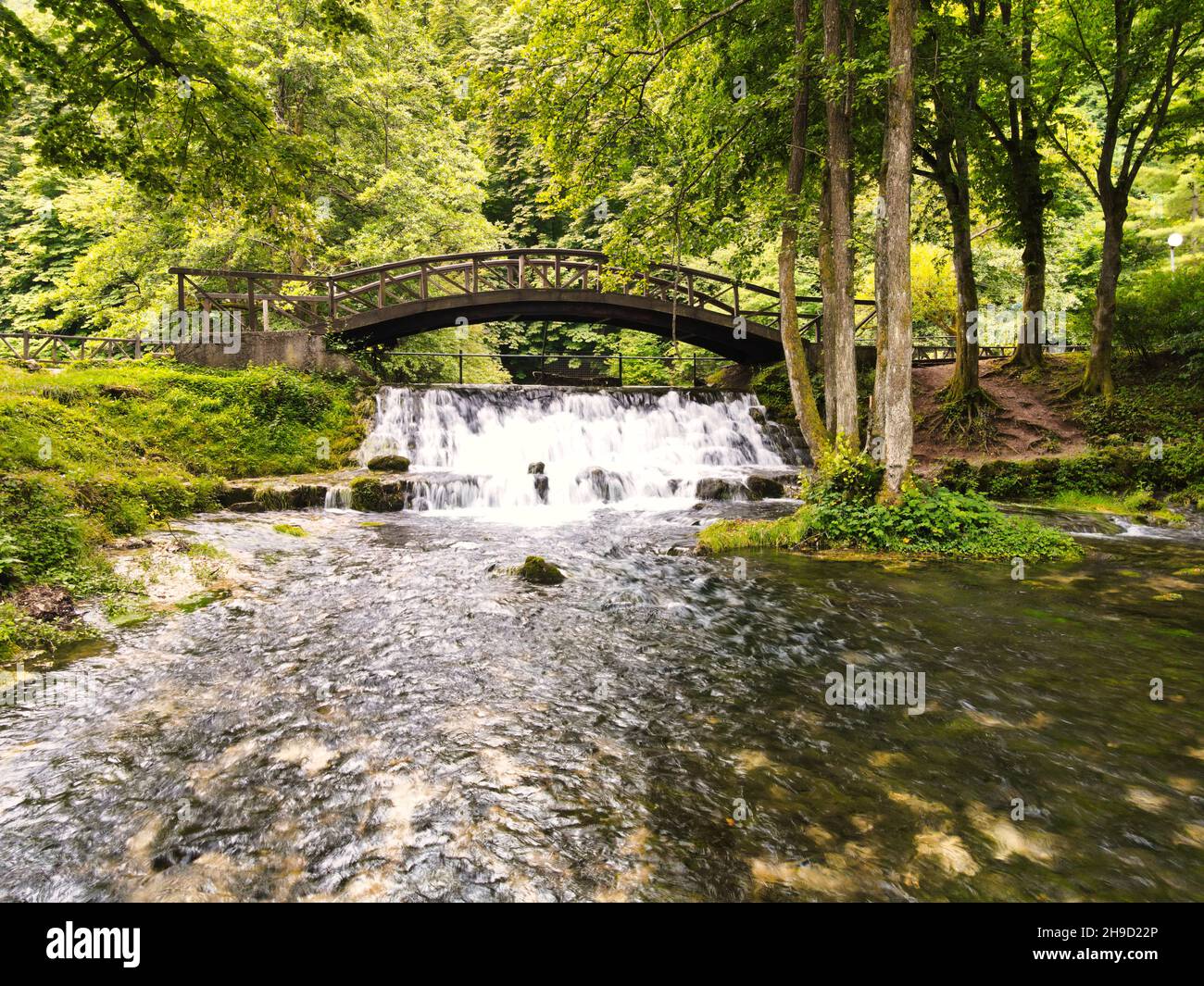 Pedestrian bridge over a waterfall Stock Photo - Alamy