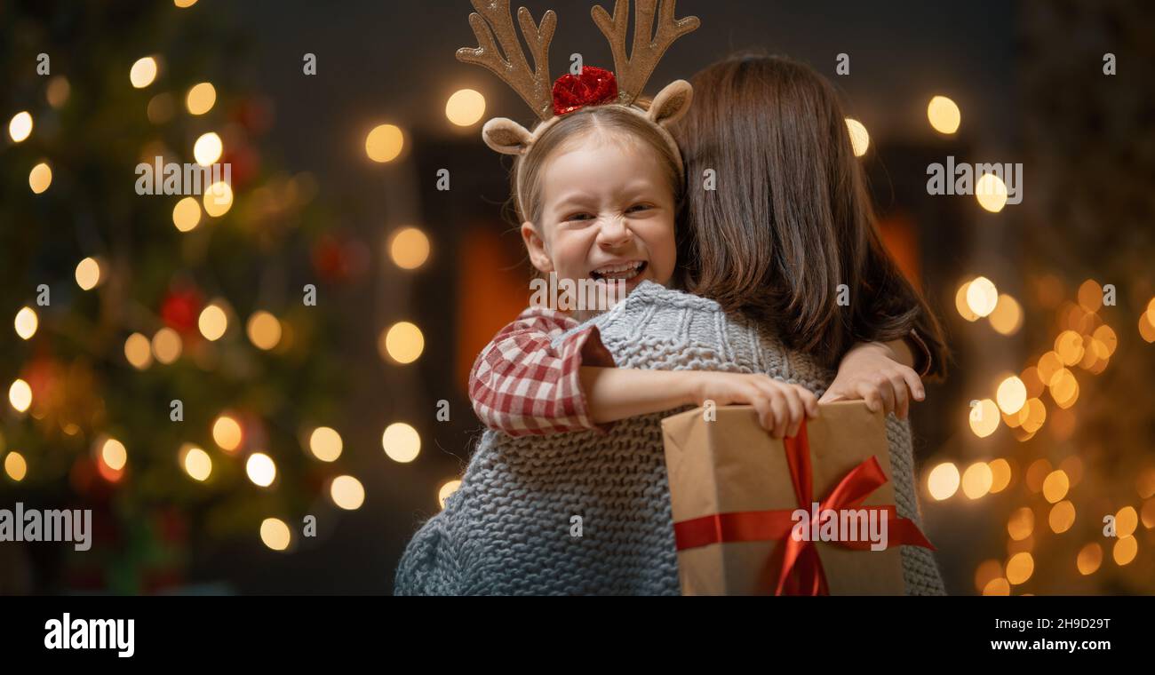 Merry Christmas and Happy Holidays. Cheerful mother and her cute ...
