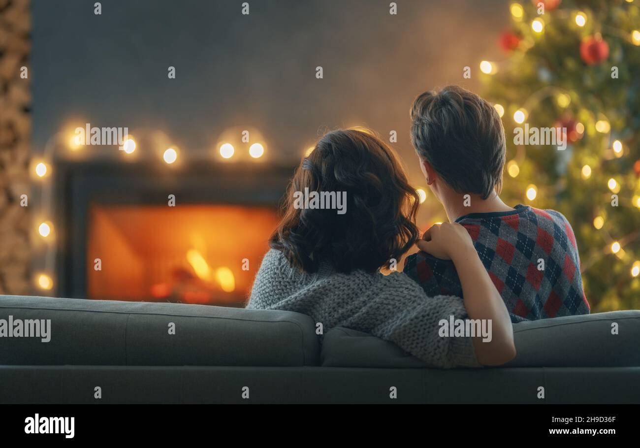 Loving couple relaxing near fireplace Christmas tree at home Stock ...