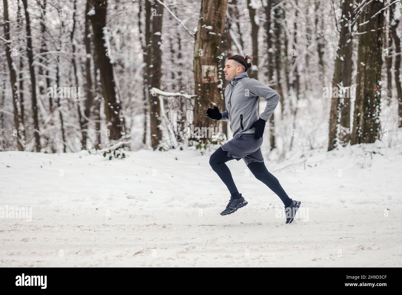 Fast sportsman sprinting in nature at snowy winter day. Winter fitness ...