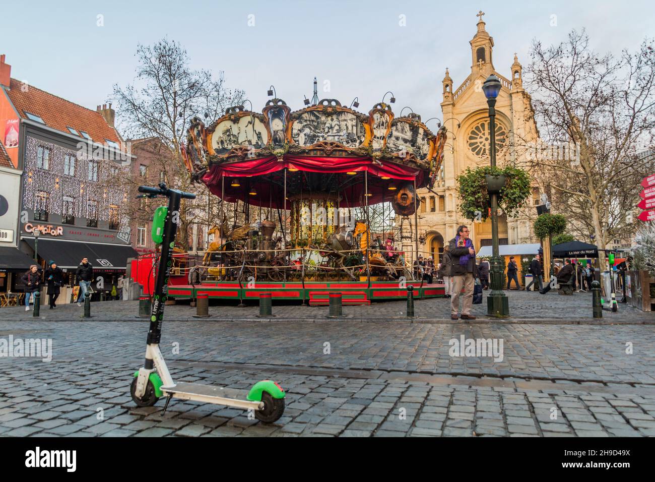BRUSSELS, BELGIUM - DECEMBER 17, 2018: Old carousel and a Lime scooter ...