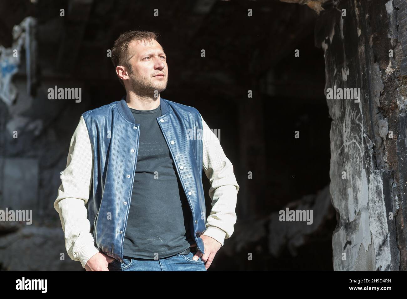 man in destroyed building against background of graffiti. Portrait of ...