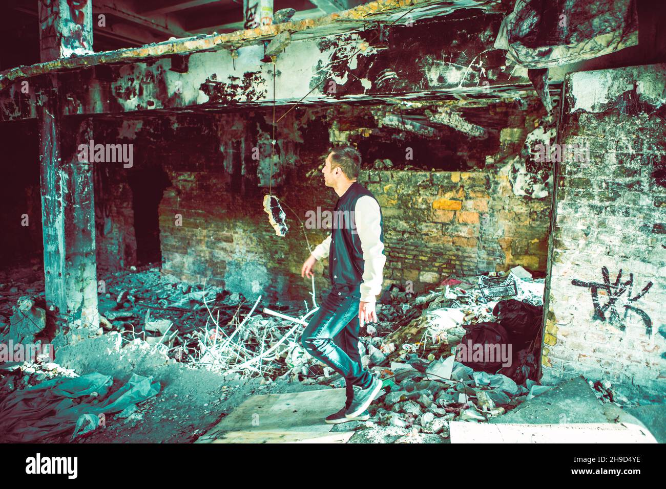 man in destroyed building against background of graffiti. Portrait of ...