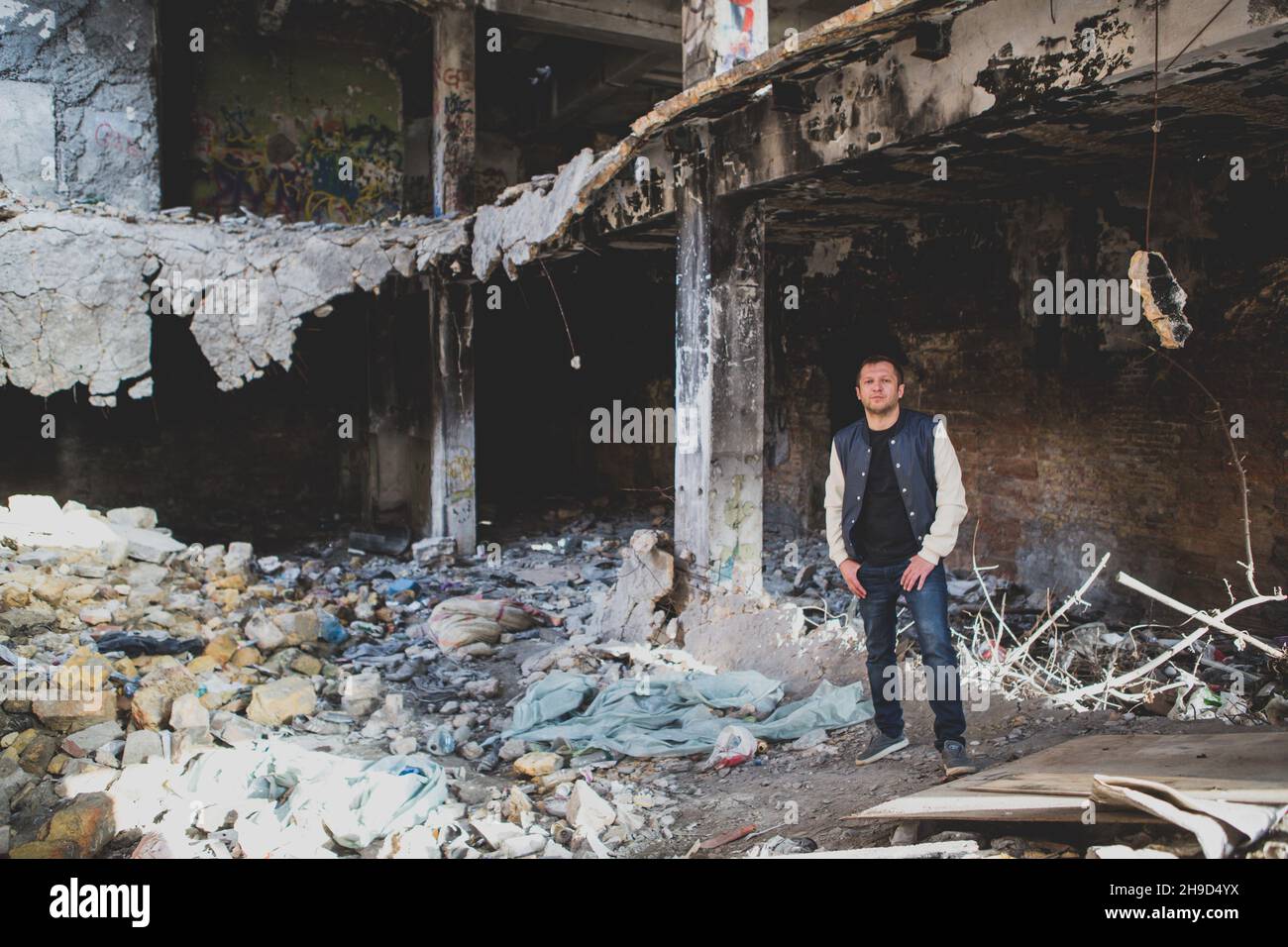 man in destroyed building against background of graffiti. Portrait of ...
