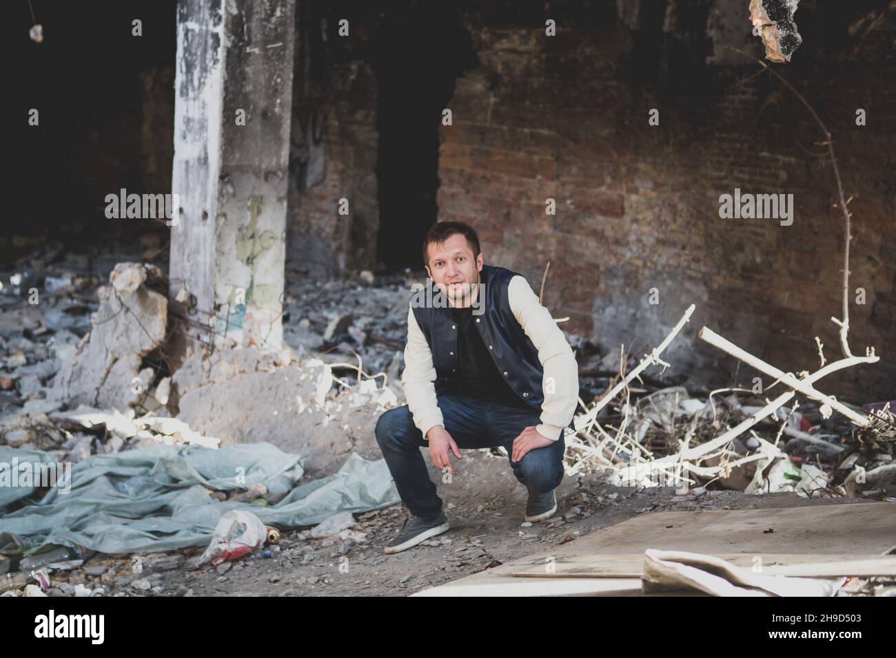 man in destroyed building against background of graffiti. Portrait of ...