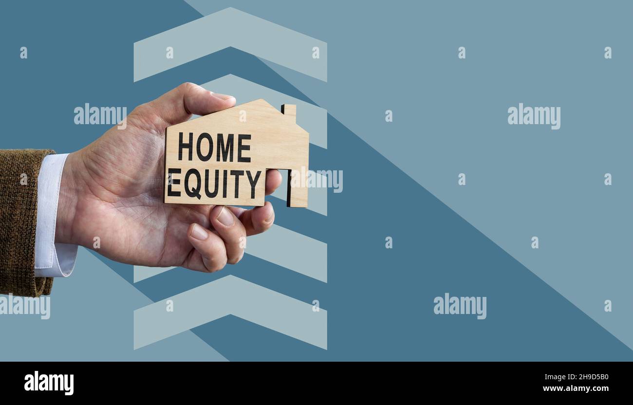 Home equity concept. Hand holds model of home Stock Photo - Alamy