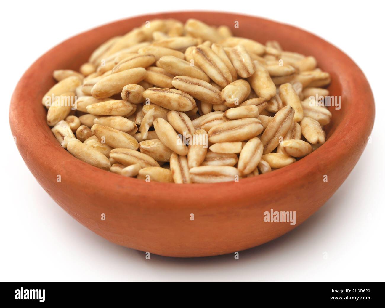 Whole oats in a bowl over white background Stock Photo - Alamy
