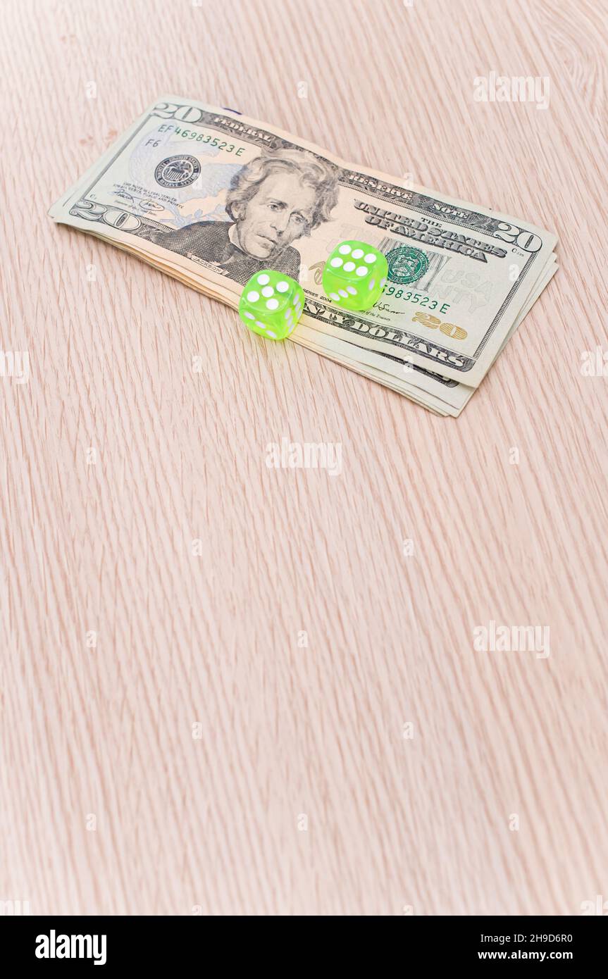 US dollars banknotes and green dice on a wooden tabletop Stock Photo ...