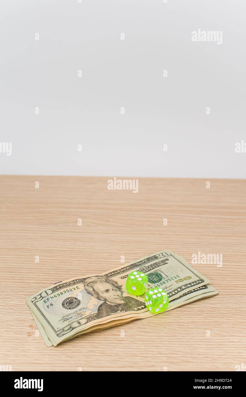 US dollars banknotes and green dice on a wooden tabletop Stock Photo ...
