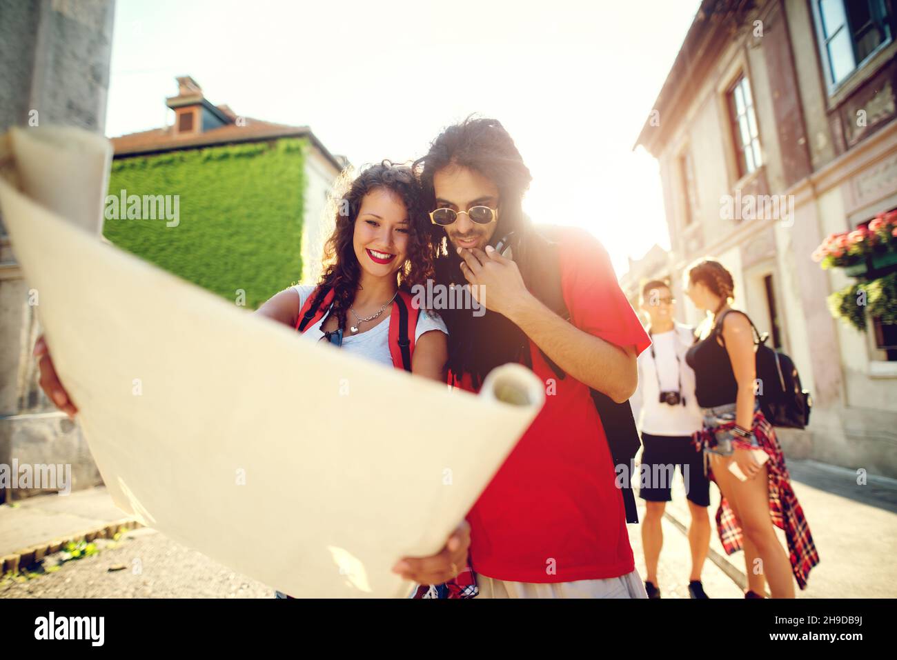 Multiracial couple looking at the map searching old city. Exploring ...